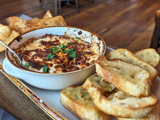 Bubbling cheese dip with golden toasted bread for dipping—a combination that has launched countless diet resets. "I'll start tomorrow" was never more justified.
