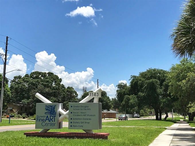 The Dunedin Fine Art Center sign stands as a colorful promise that creativity flourishes here, where palm trees and paintbrushes coexist in perfect harmony.