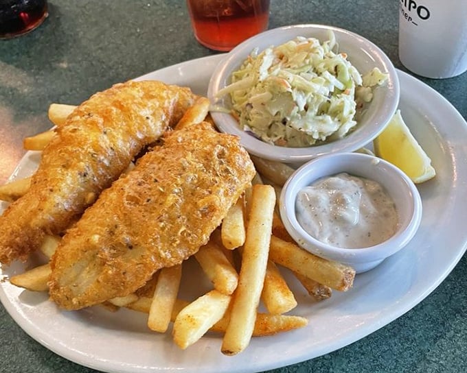 Fish so perfectly golden it belongs in Fort Knox, with fries standing at attention like they know they're part of something important.