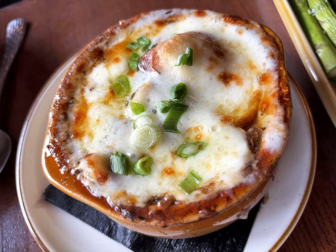 This isn't just French onion soup—it's a bubbling cauldron of cheese-capped comfort that makes you wonder why anyone eats anything else.