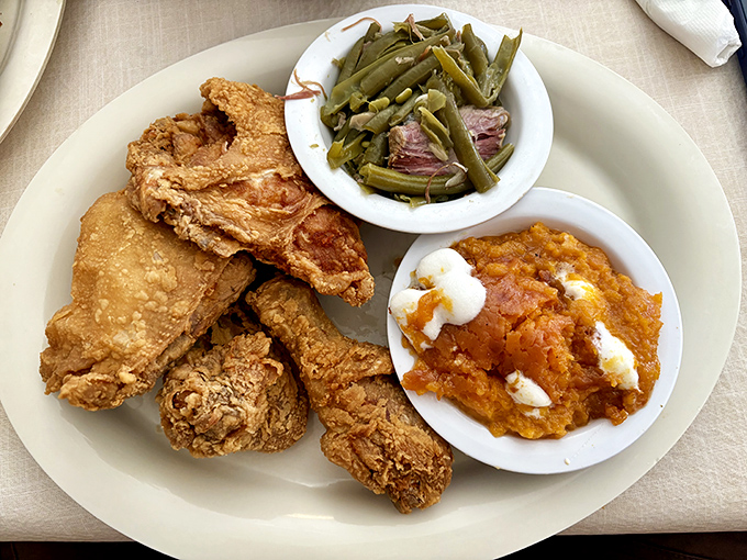 Fried chicken with that perfect golden crust sitting alongside green beans and sweet potato soufflé—the holy trinity of Southern comfort.