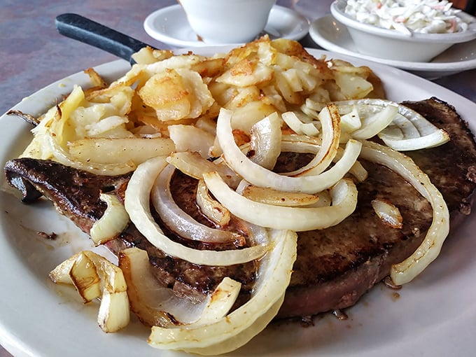 A steak topped with sautéed onions and home fries – proof that diners understand the art of simple, satisfying food better than anywhere else.