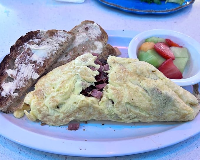 This isn't just an omelet—it's a fluffy yellow envelope delivering a love letter of ham and cheese to your taste buds.