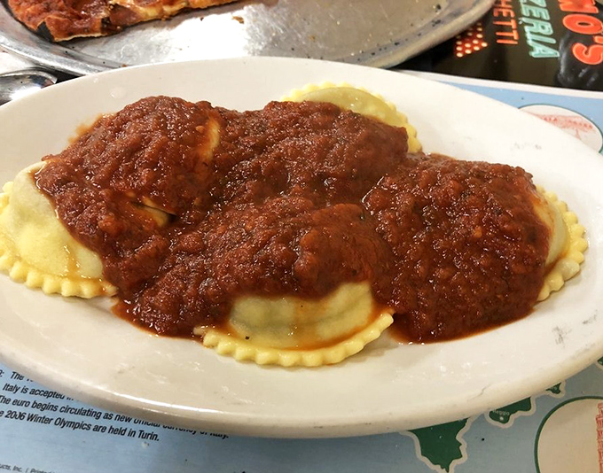 Ravioli swimming in a sea of rich tomato sauce—pasta pillows that have comforted more souls than any therapist's couch ever could.