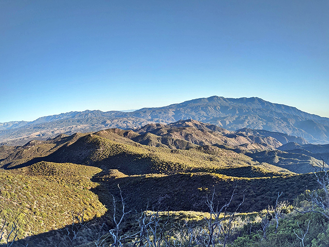 Mountain layers unfold like nature's tiramisu – each ridge a different shade of purple and gold in the late afternoon light.