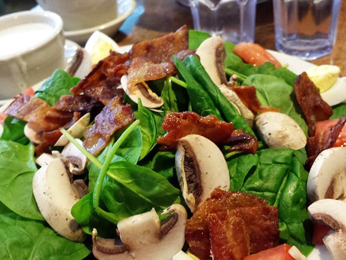 This isn't just a salad—it's a carefully orchestrated arrangement of fresh spinach, mushrooms, and crispy bacon that makes eating greens feel like cheating.