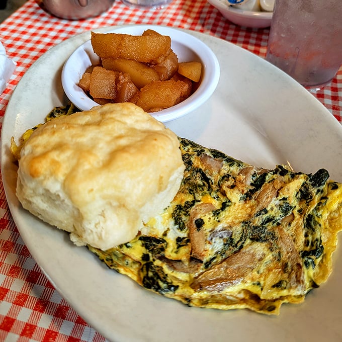 This isn't just an omelet—it's a fluffy yellow canvas painted with flavors, accompanied by a biscuit that defies gravity.
