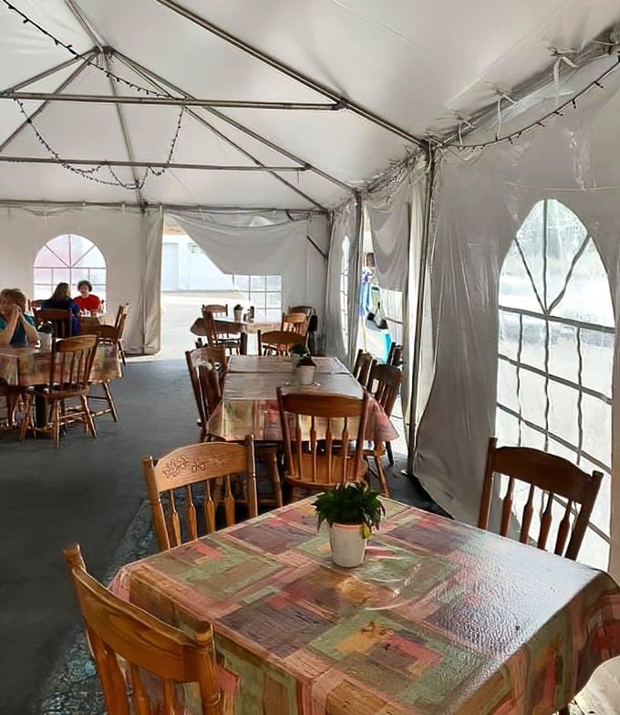 The outdoor tent dining area—where simple wooden chairs and patterned tablecloths create an unexpected charm away from the main dining room.