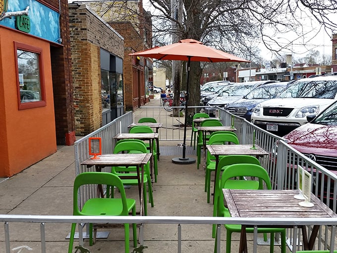 The sidewalk seating area's bright green chairs pop against the urban backdrop—Madison's answer to Parisian cafe culture.