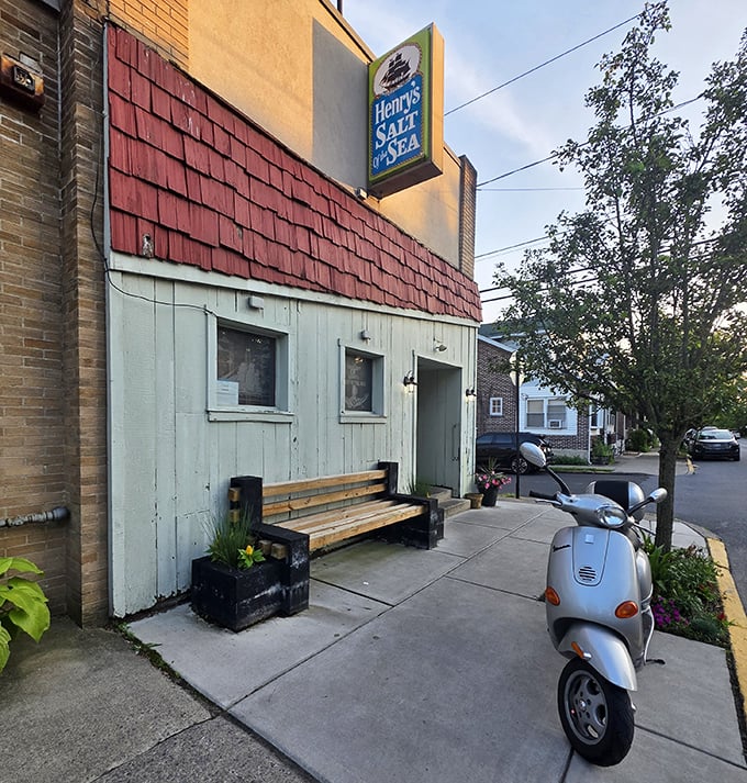 Outside sits a humble bench and a Vespa—both promising journeys, though only one leads to seafood paradise behind that unassuming door.