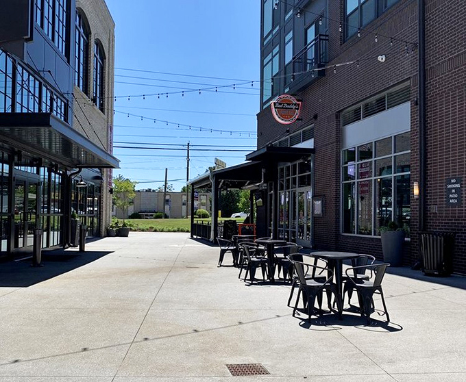 Outdoor tables bask in Georgia sunshine between modern buildings—the perfect spot for people-watching while tackling your burger creation.