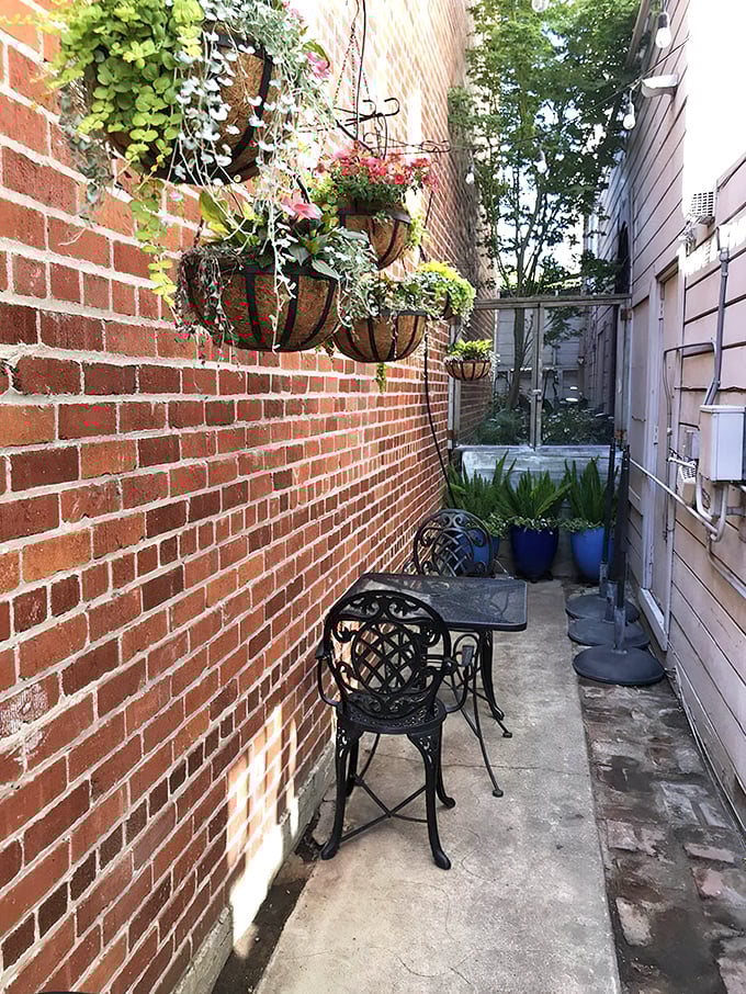 The secret courtyard offers a brick-walled sanctuary for intimate conversations or solo dining adventures away from Main Street's hustle.