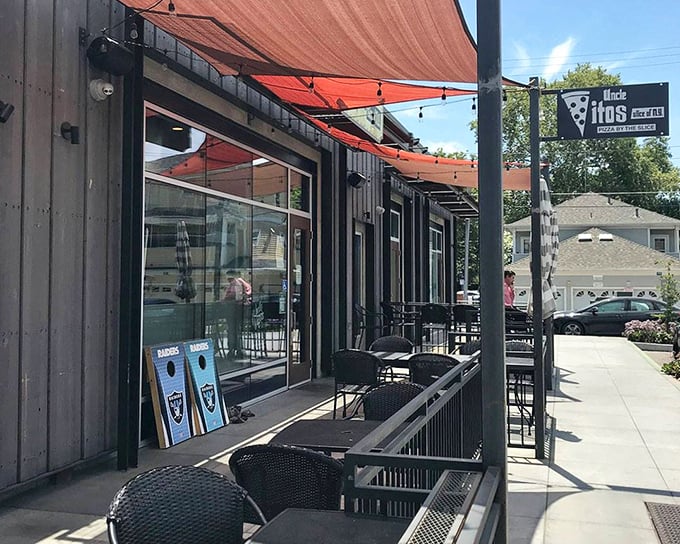 The sidewalk seating area – where pizza voyages begin and diet promises end. Those red awnings practically whisper, "Come sit a while."