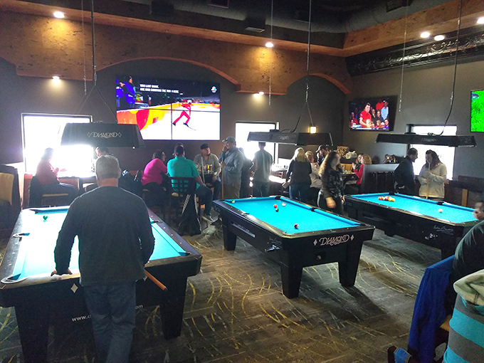 The game room buzzes with friendly competition – because nothing builds an appetite like thoroughly destroying your friends at pool.