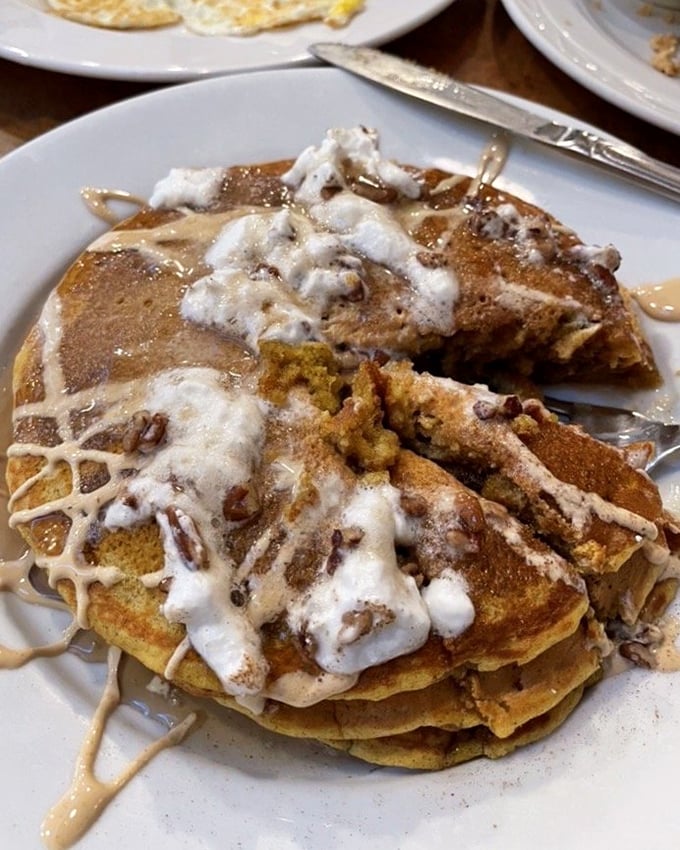 Pumpkin pancakes drizzled with icing and topped with pecans—autumn's greatest gift to breakfast, available whenever your heart desires it. 