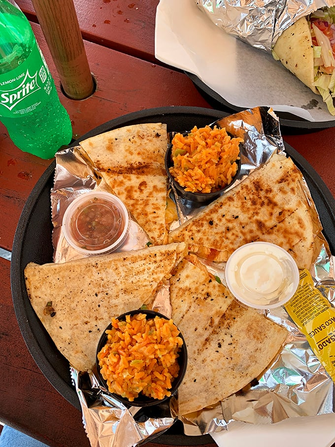 A quesadilla cut with geometric precision, surrounded by dipping options that suggest someone in the kitchen understands the importance of sauce architecture.