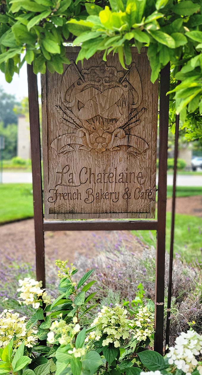 A wooden sign nestled among flowers—like finding a secret garden entrance to a world where calories don't count and time slows down.