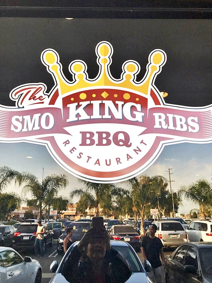 The crown logo says it all—in the kingdom of ribs, this place rules. Reflected palm trees remind you that yes, great barbecue can indeed exist in California.