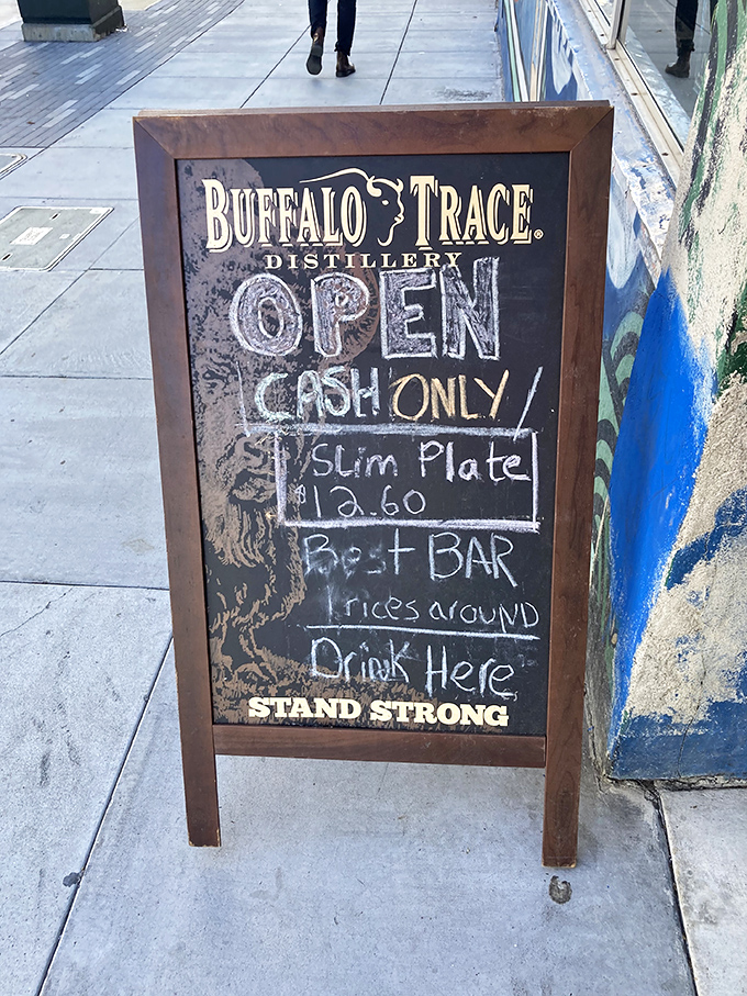 The sidewalk sign speaks truth – cash only, slim plates, and a promise of drinks that won't require a second mortgage.