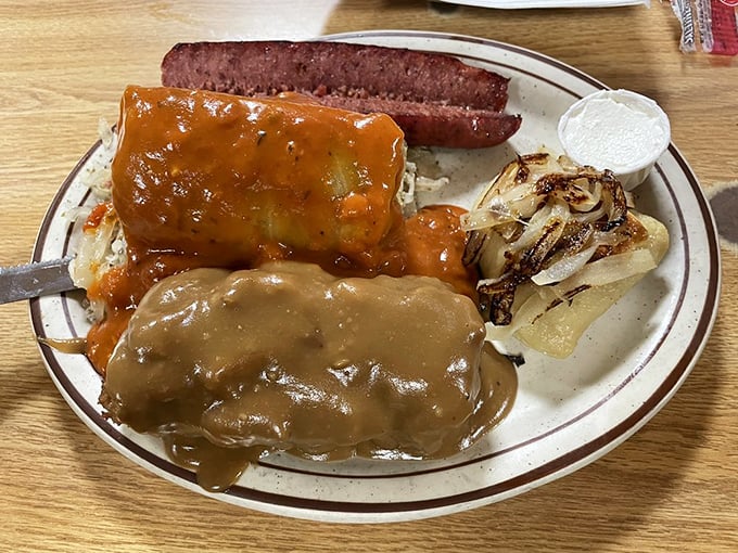 A plate that tells Cleveland's cultural story – cabbage rolls and smoked sausage sharing space in perfect harmony, smothered in savory gravy.