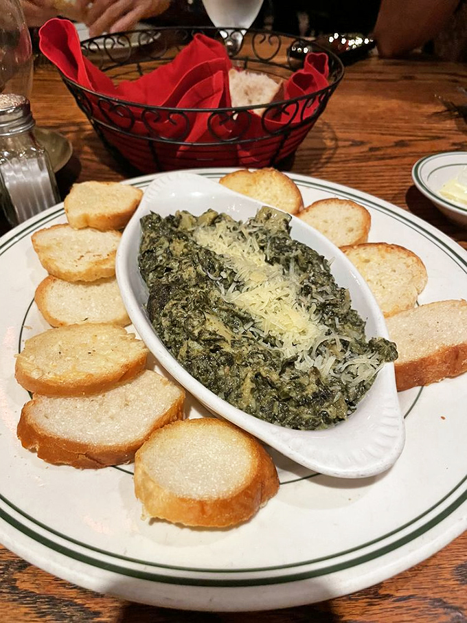The spinach artichoke dip arrives surrounded by toasted bread like courtiers attending a queen—rich, indulgent, and impossible to resist.