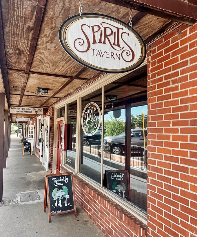 Spirits Tavern's wooden sign swinging gently above the sidewalk practically whispers, "Come in, the stories are waiting."