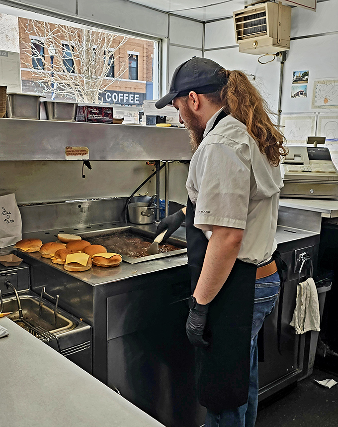 The grill master at work—where burger alchemy happens with the practiced precision of someone who knows their craft.