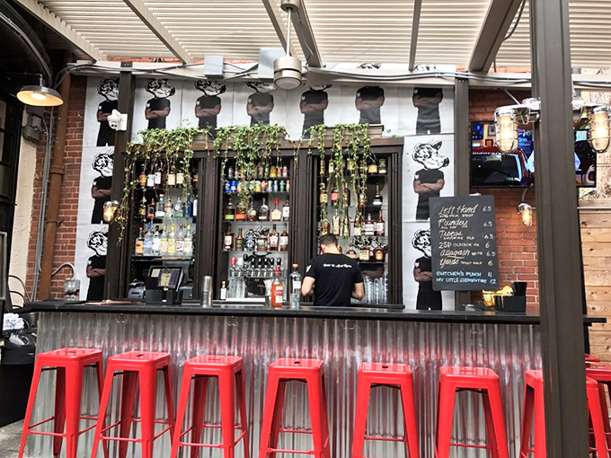 Bright red stools and a lively bar setup create the perfect inviting spot to enjoy drinks and good company at Butcher Bar.