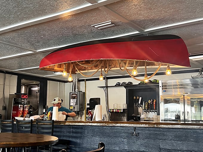 Behind the counter, where the magic happens. That red canoe hanging from the ceiling isn't just décor—it's a nod to the waters that provide the restaurant's treasures.