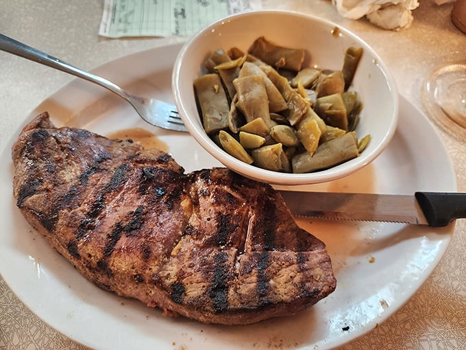 A steak with grill marks so perfect they could be taught in geometry class, paired with green beans that actually taste like vegetables should.