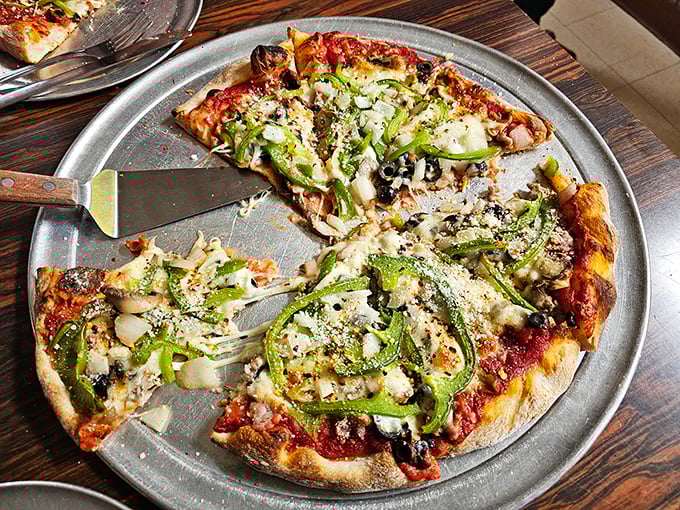 A supreme pizza that actually deserves the name—each topping placed with purpose, the green peppers curling slightly at the edges from the heat.