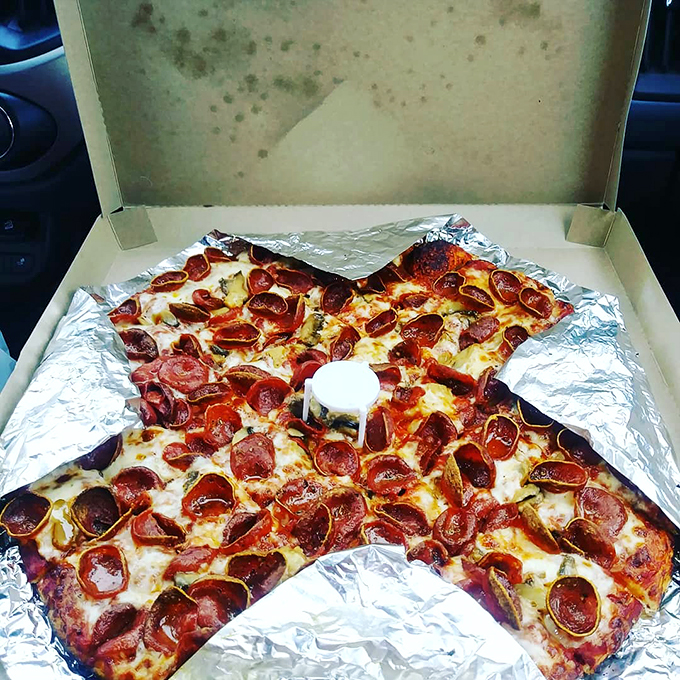 The take-home pizza box—a cardboard treasure chest containing tomorrow's breakfast that somehow tastes even better cold at 9 AM. 