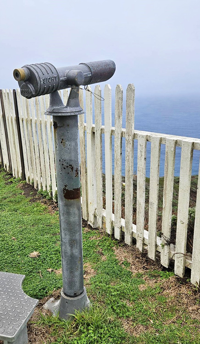 The vintage telescope stands ready for visitors to spot whales, ships, or perhaps scan the horizon for incoming fog—a lighthouse keeper's nemesis.