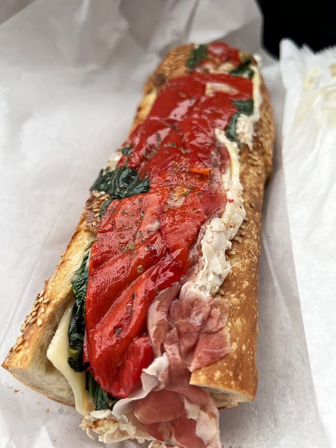 This sandwich isn't just food—it's architecture. Layers of meat, roasted red peppers, and greens create a color palette that's as beautiful as it is delicious.