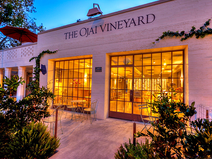 The Ojai Vineyard's tasting room glows like a lantern at dusk, beckoning wine enthusiasts to sample locally produced vintages in sophisticated surroundings.