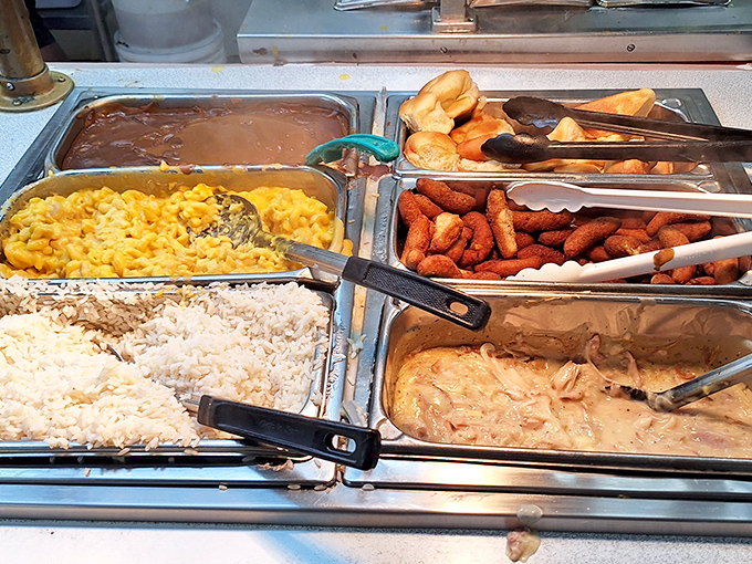The buffet line—where decisions become impossible and "I'll just take a little of everything" becomes your mantra. Mac and cheese gleams with cheesy promise.