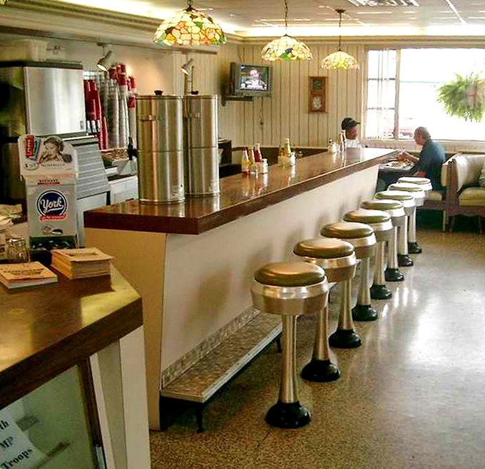 The counter seating area—where solo diners become regulars and regulars become family. Those vintage stools have heard decades of local stories.