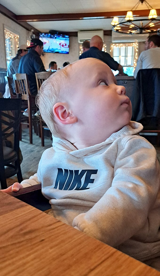 Even the youngest patrons seem mesmerized by Herb's atmosphere—this little one is clearly contemplating ordering the burger or going straight for dessert.
