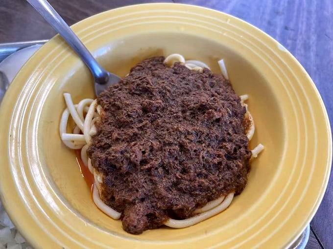 Chili spaghetti on a sunny yellow plate—a Midwestern classic that found its California home, proving comfort food knows no geographical boundaries.