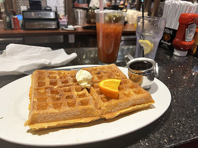 A waffle that doesn't just sit on your plate—it commands attention with golden perfection and a supporting cast of fresh fruit.