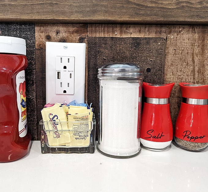 The condiment station – salt, pepper, and sweetener packets arranged with the precision of a NASA launch sequence.