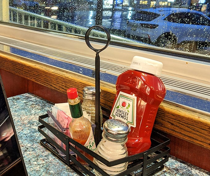 The condiment caddy—that miniature stage where ketchup, hot sauce, and sweetener packets perform their supporting roles in your dining experience.
