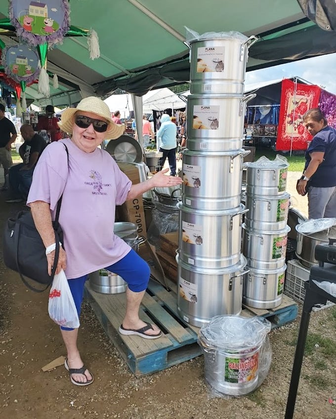 Kitchen equipment stacked to impressive heights. The vendor proudly showcases cooking pots that could handle anything from family reunions to small revolutions.