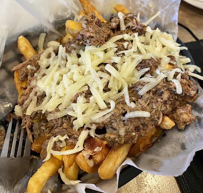Loaded fries—where potatoes fulfill their highest calling, crowned with savory pulled meat and melted cheese in a glorious celebration of excess.