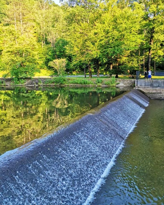 Water spills over this peaceful dam near the park, creating a meditative soundtrack for daytime explorers seeking tranquility.