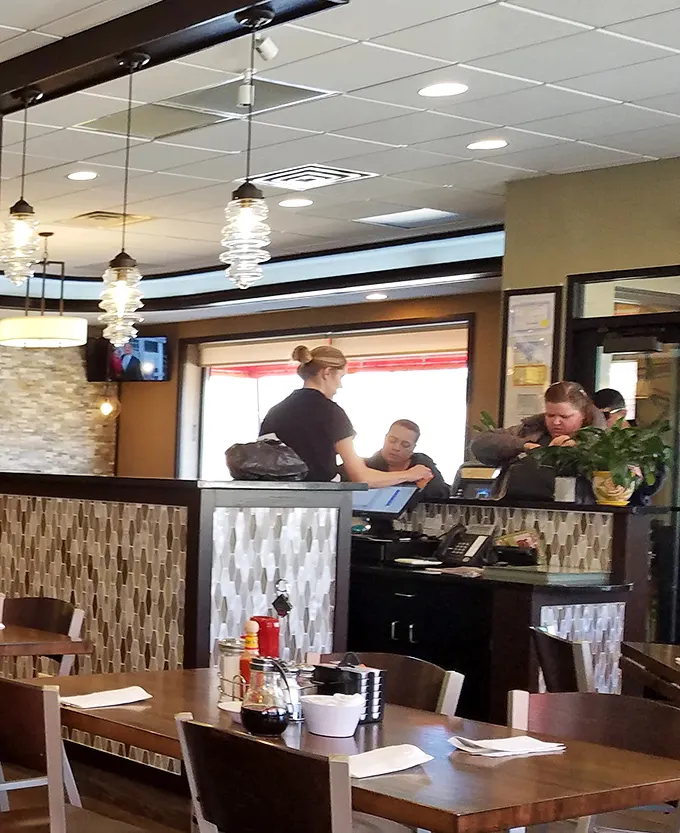 The host station—that first checkpoint on your journey to breakfast paradise, where friendly faces guide hungry pilgrims to their pancake destinations.