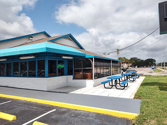 Outdoor seating with cheerful blue picnic tables offers the quintessential Florida dining experience—breakfast with a side of sunshine and gentle breezes.