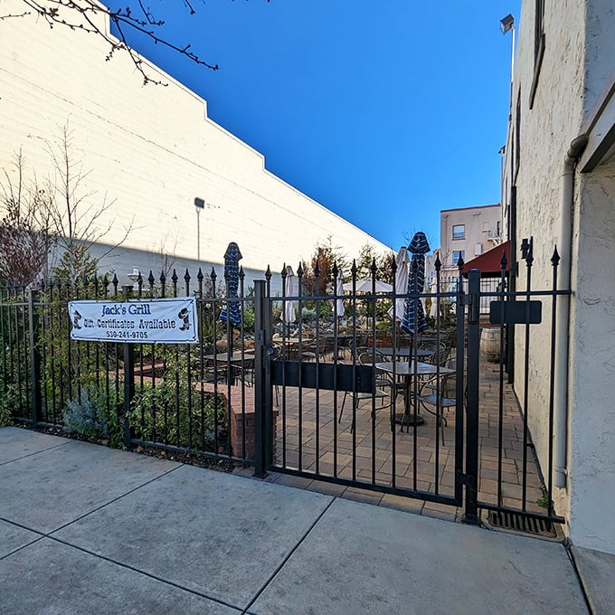 The outdoor patio waits behind wrought iron gates – a secret garden for those who prefer their steak with a side of fresh air.