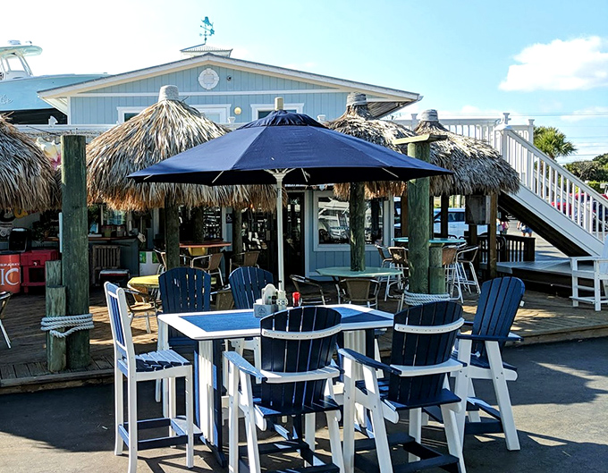 The outdoor seating area isn't just tables and chairs—it's Florida's living room, where Adirondack blue meets endless sky and waterfront views come standard.