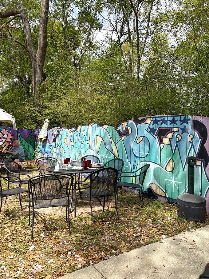 Outdoor seating against a graffiti backdrop—urban breakfast oasis where nature and street art create the perfect dining soundtrack.